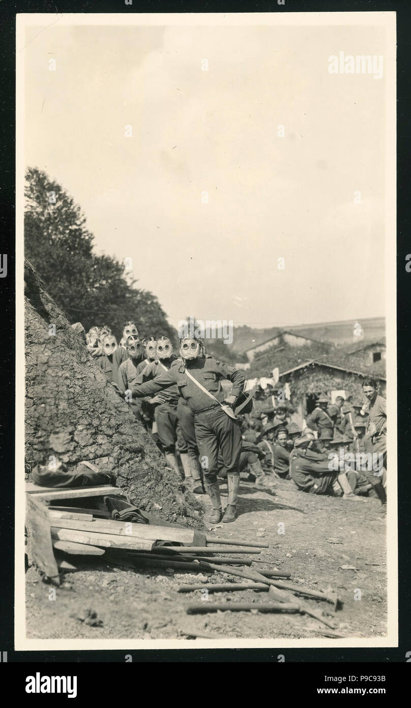 A line of soldiers posed, facing front, standing next to earthenwork ...