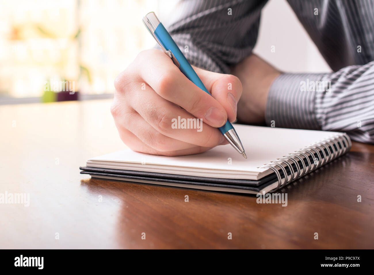 Front View Of A Man In Business Shirt Writing In A Blank Notepad With A ...