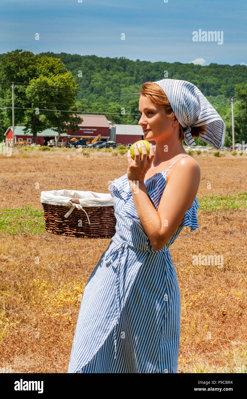 Farm. Woman enjoying nature in meadow. Farmer hold wicker basket in the ...