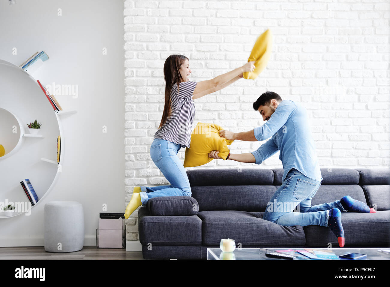 Portrait of Young Couple Playing Pillow Fight Stock Photo - Alamy