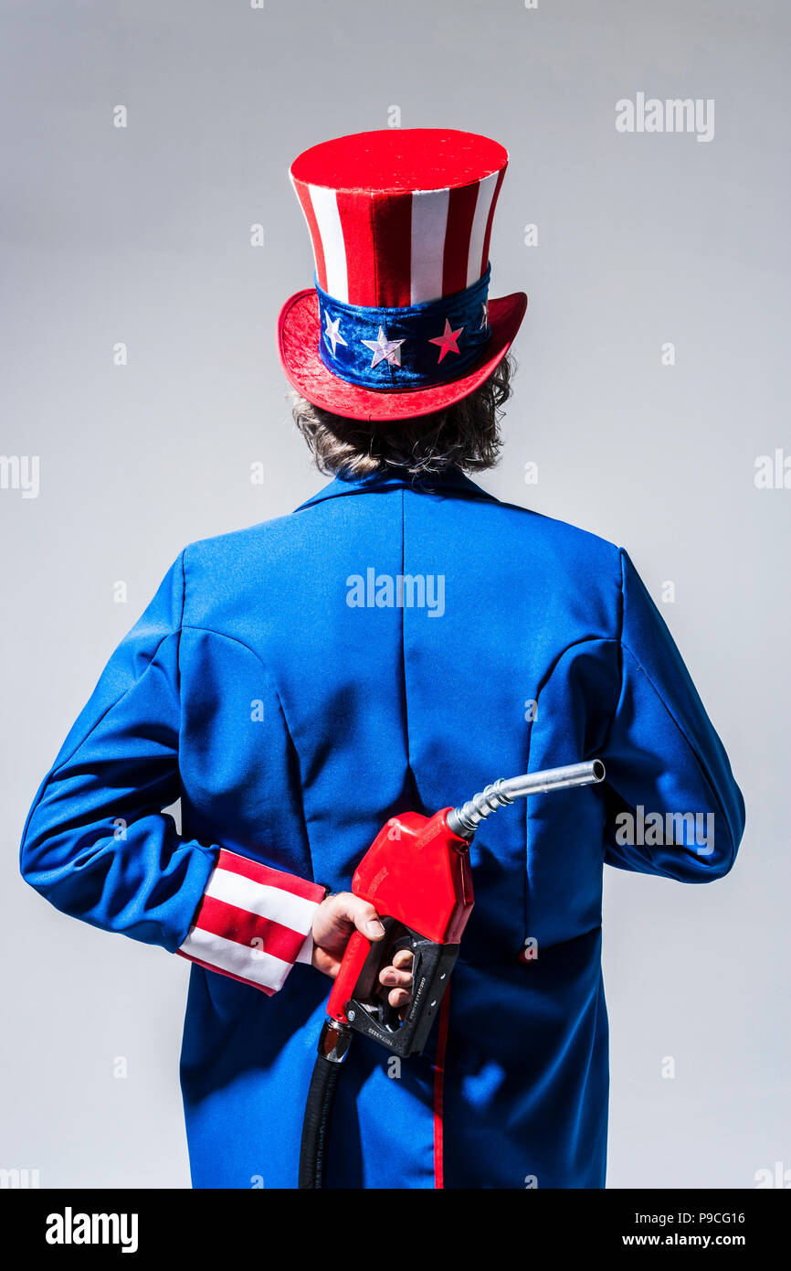 Uncle Sam character as seen from behind holding a gasoline pump nozzle behind his back Stock ...