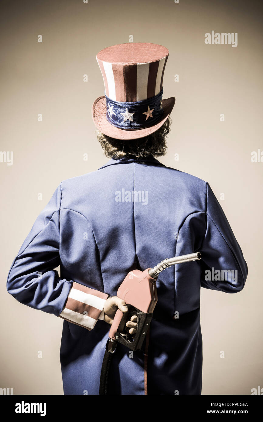 Uncle Sam character as seen from behind holding a gasoline pump nozzle ...