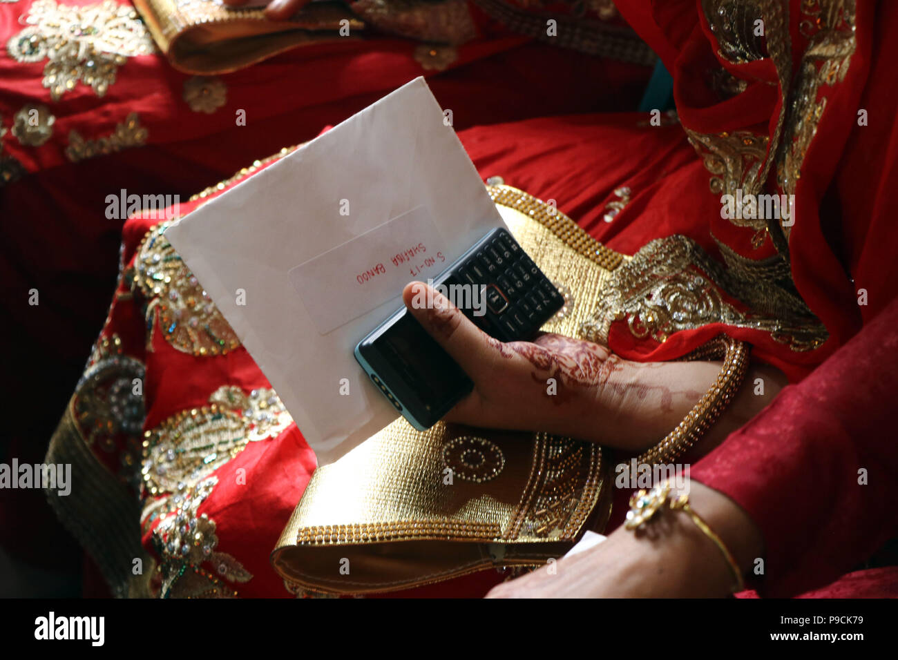 A Kashmiri muslim bride watches her marriage ceremony being performed ...