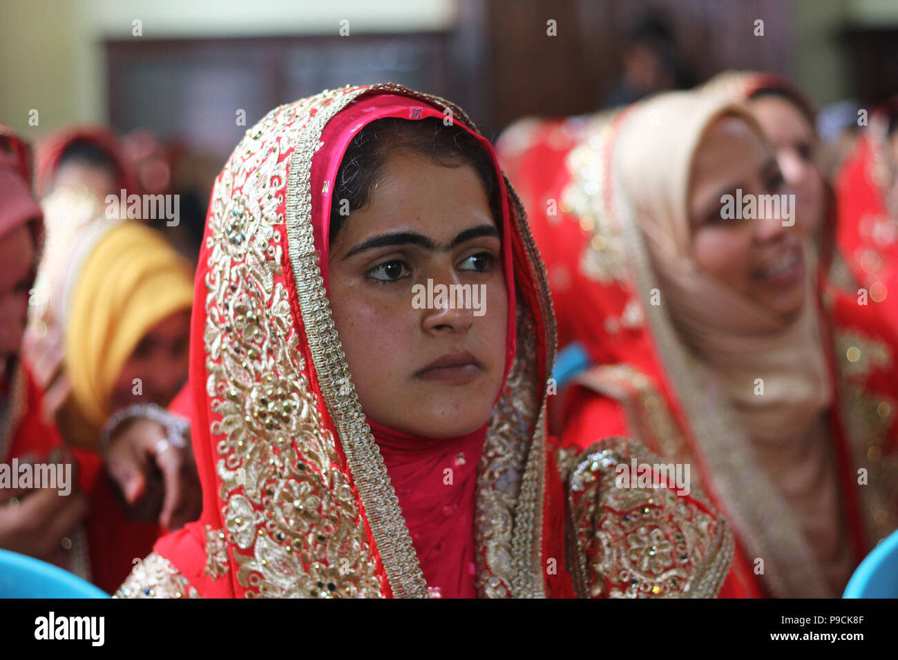 A Kashmiri muslim bride watches her marriage ceremony being performed ...