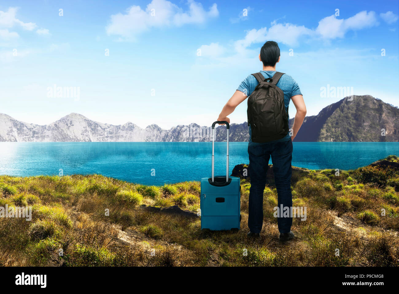 Back view of asian traveler man with suitcase enjoying lake view at ...