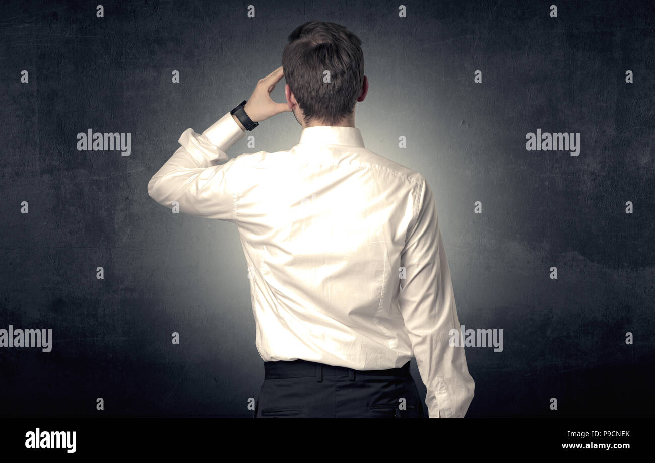 Young businessman standing and thinking alone Stock Photo - Alamy
