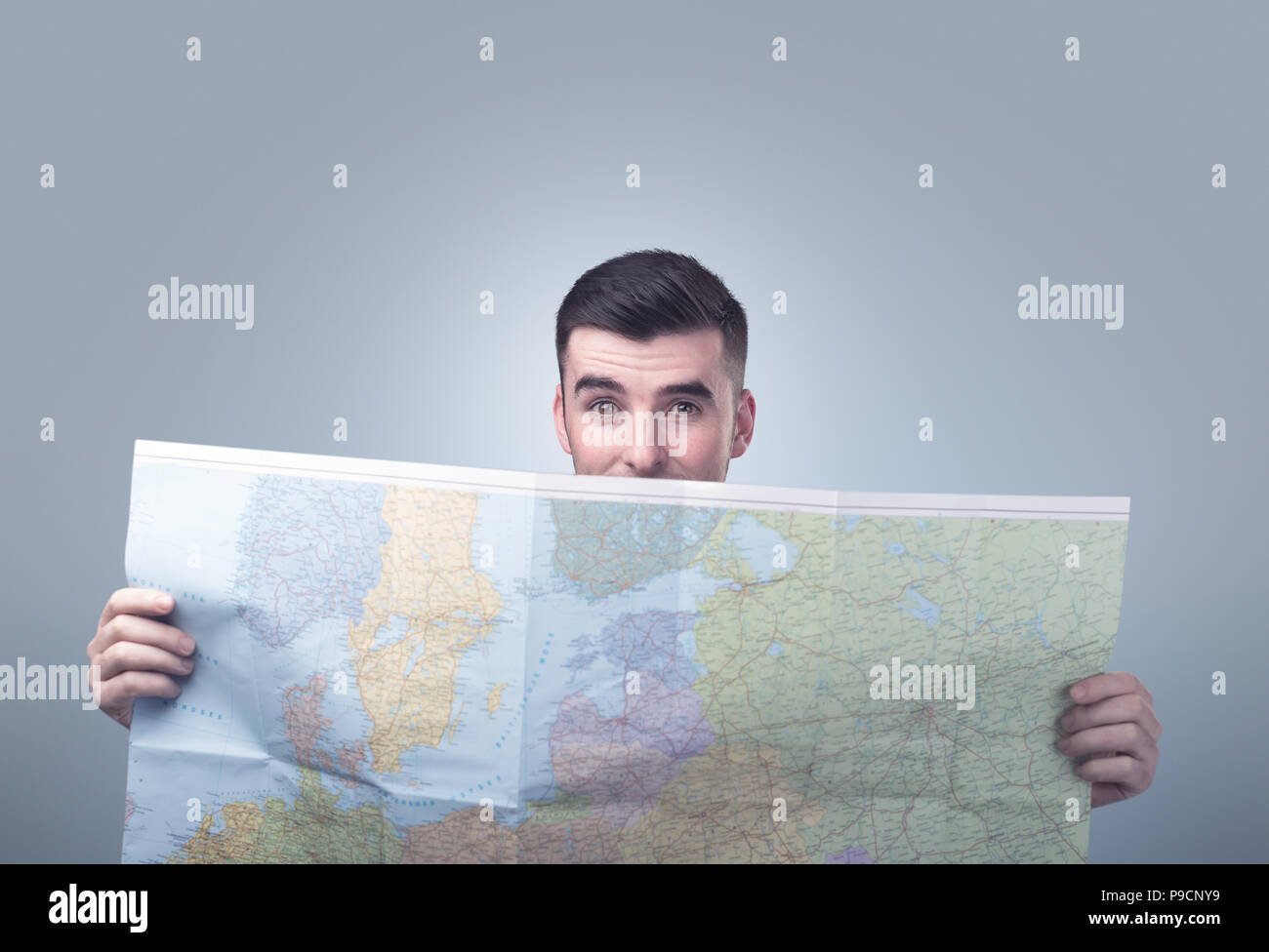 Handsome young man holding map Stock Photo - Alamy