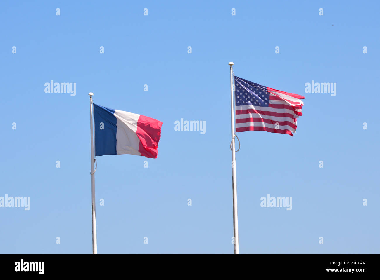 French and American flags flying together against a blue sky Stock ...