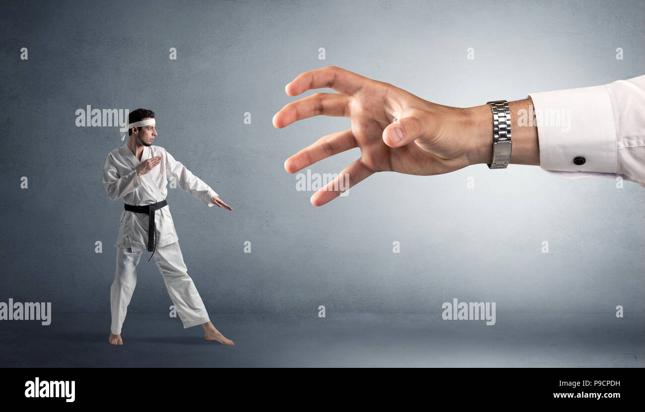 Small karate man fighting with big hand Stock Photo - Alamy