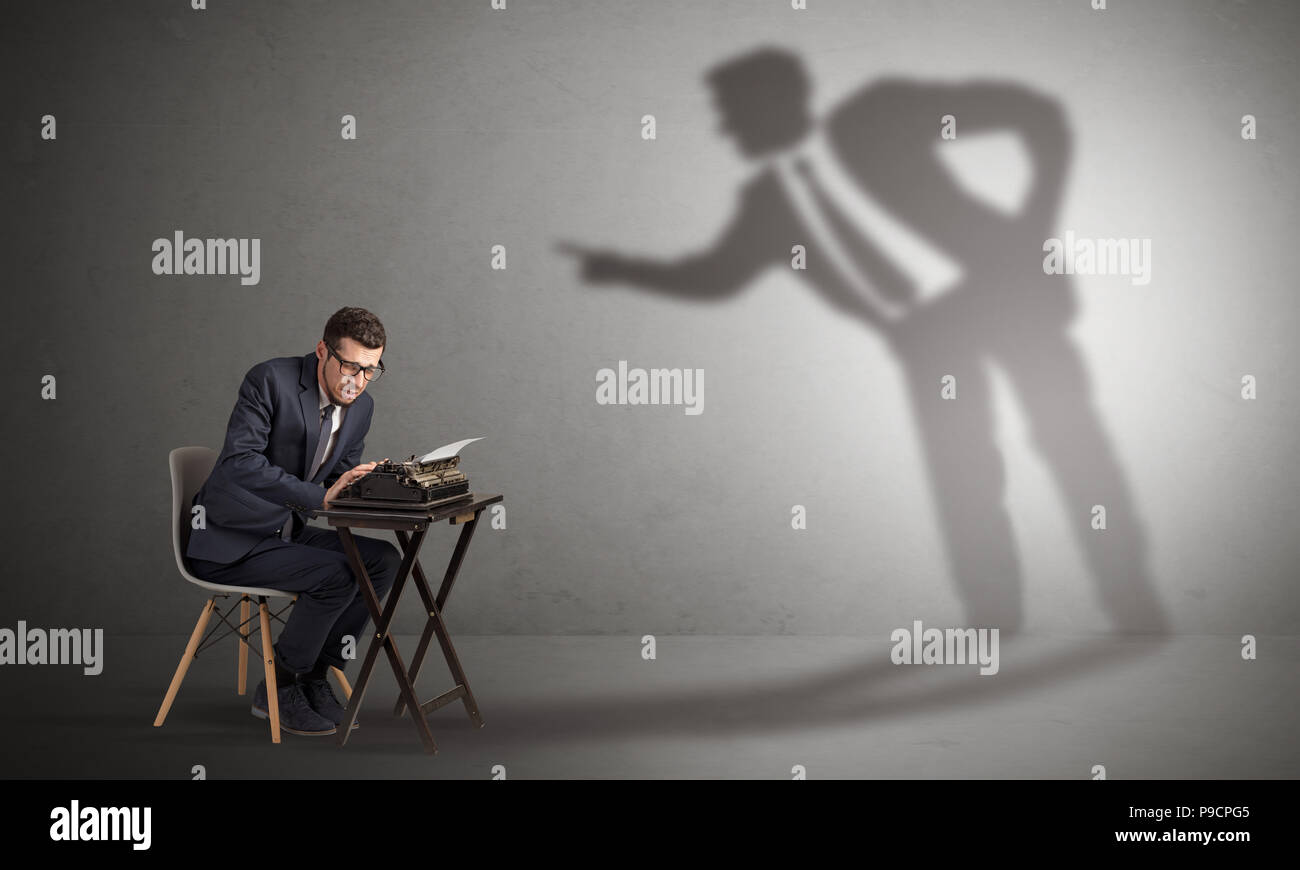 Little man working and a big shadow arguing with him Stock Photo - Alamy