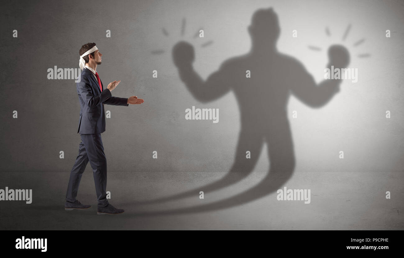 Businessman trying to fight with his unarmed shadow Stock Photo - Alamy