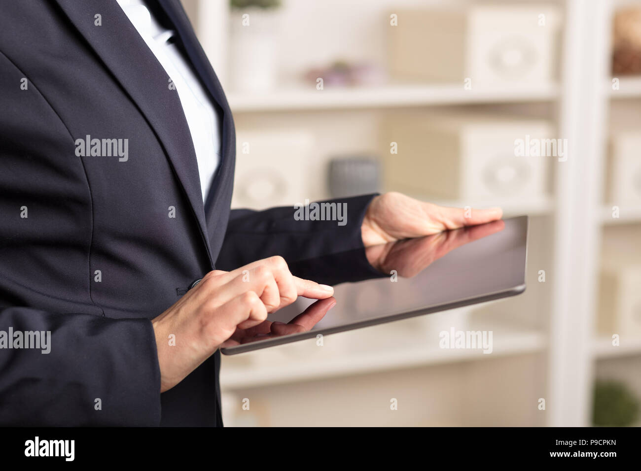 Business woman below chest using tablet in a homey environment Stock ...