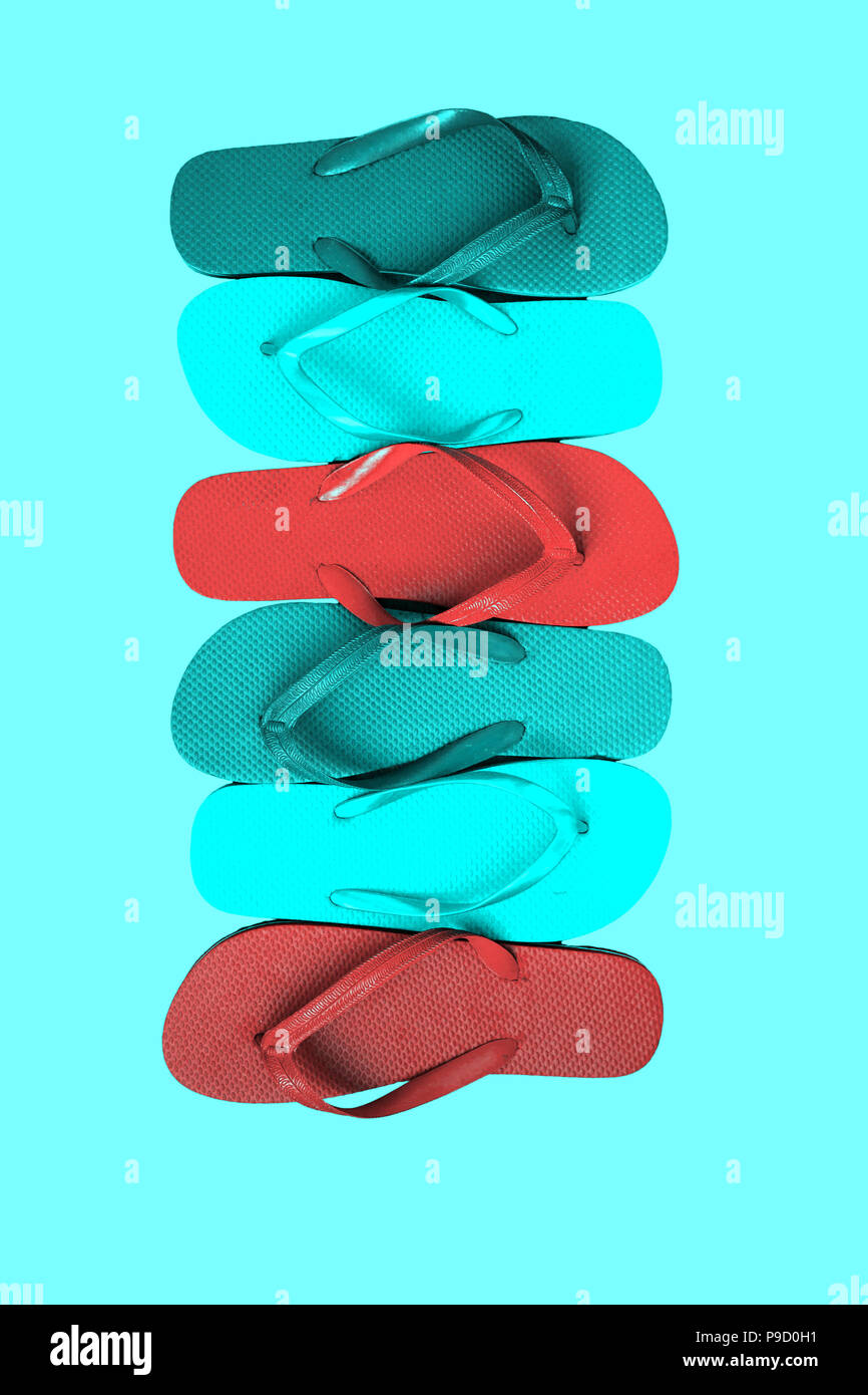 Several pairs of multi-colored rubber flip-flops exhibited in a row ...