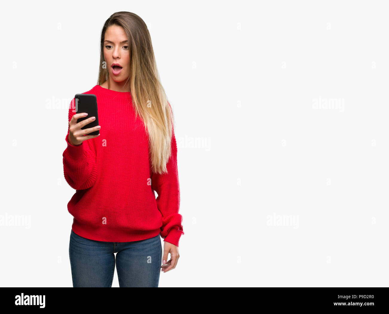 Beautiful young woman using smartphone scared in shock with a surprise ...