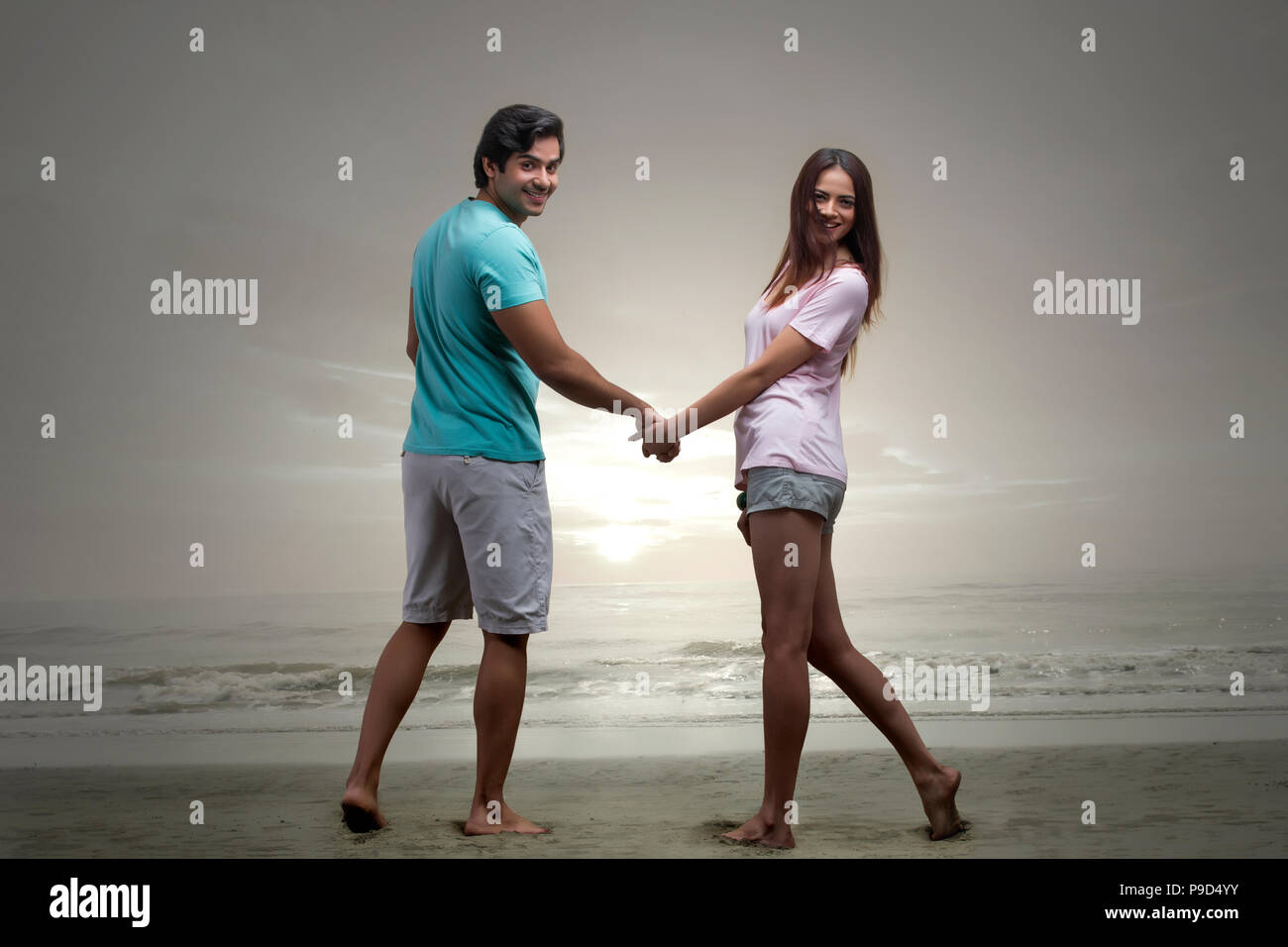 Happy couple hand in hand on the beach Stock Photo - Alamy