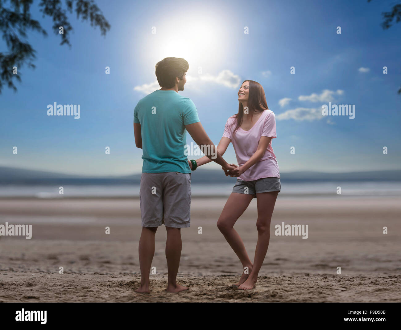 Happy couple hand in hand on the beach Stock Photo - Alamy