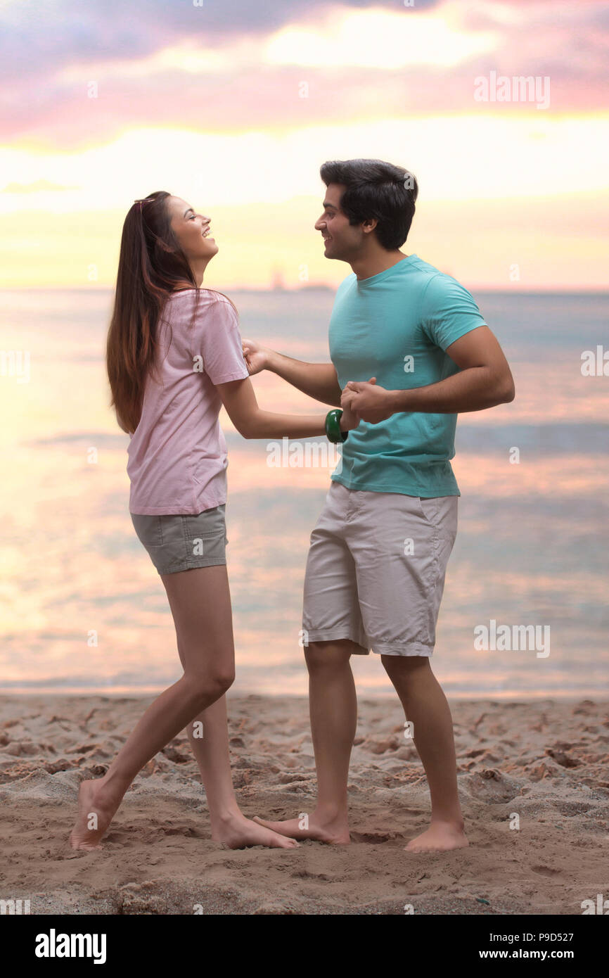 Happy couple hand in hand on the beach Stock Photo - Alamy