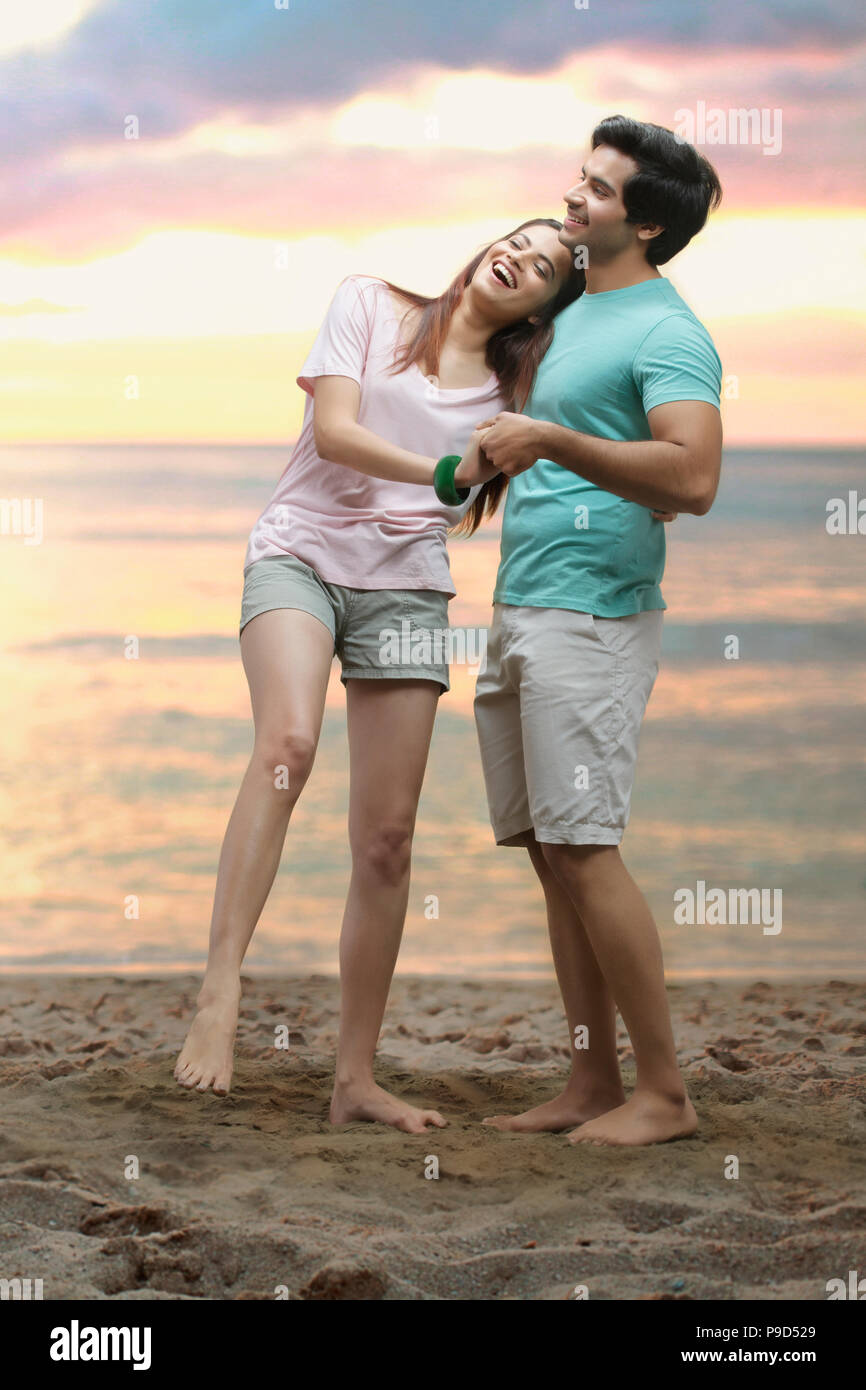 Happy couple hand in hand on the beach Stock Photo - Alamy