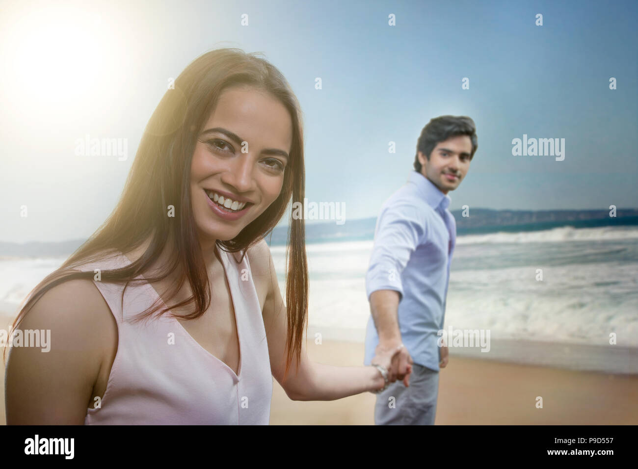 Portrait of young couple holding hand in hand on beach Stock Photo - Alamy