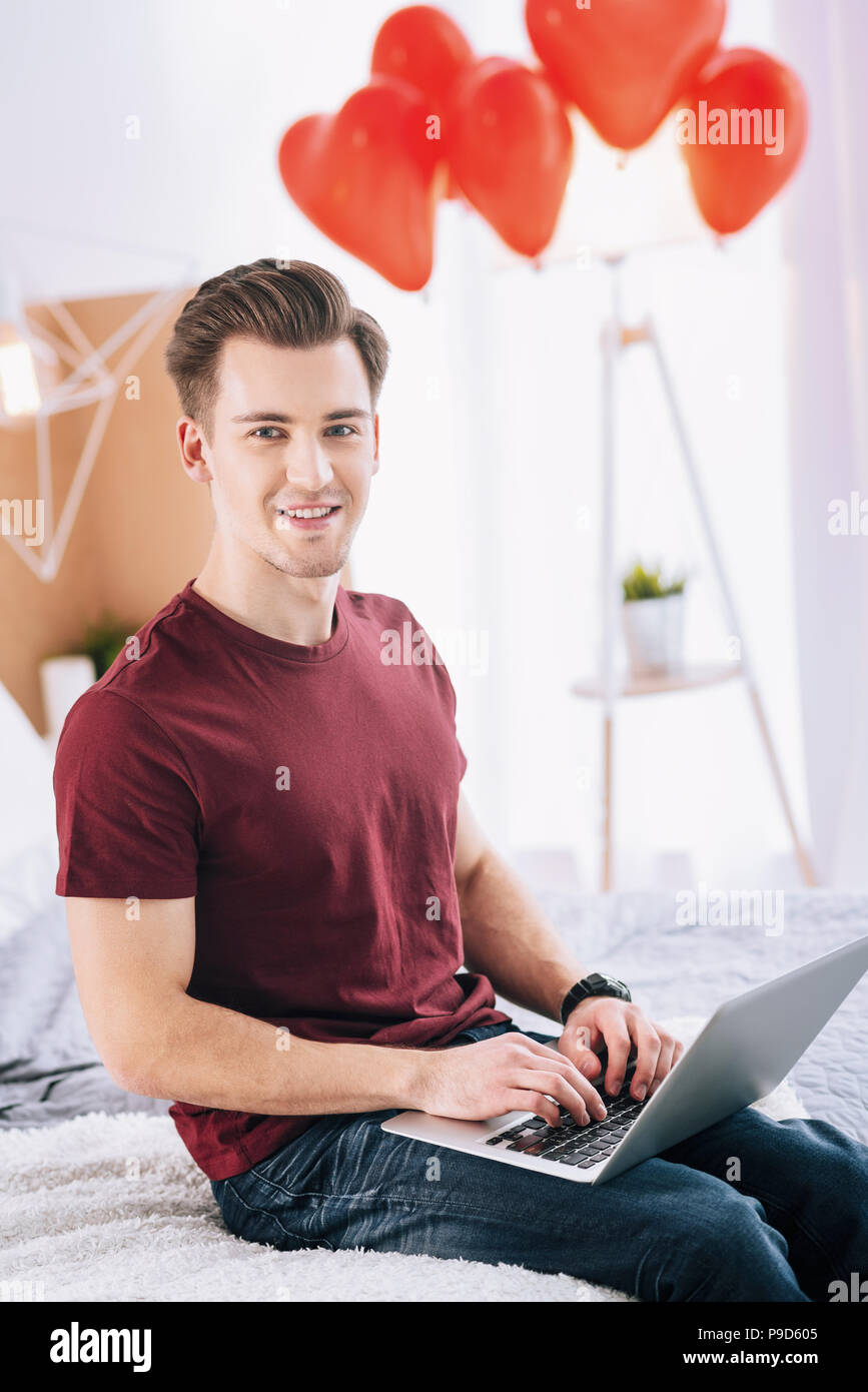 Delighted young man sitting in semi position Stock Photo - Alamy