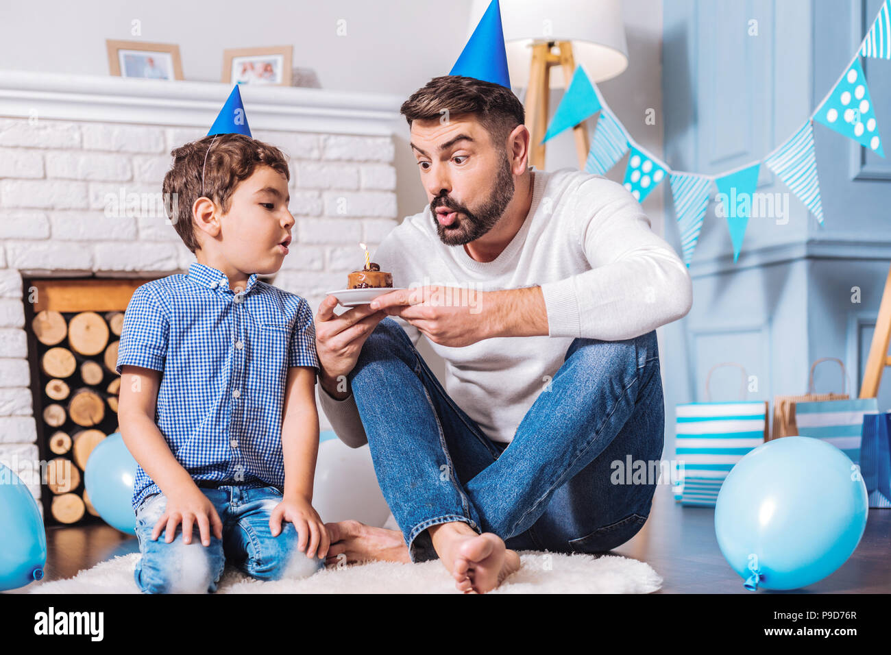Funny man looking at little fancy cake Stock Photo - Alamy