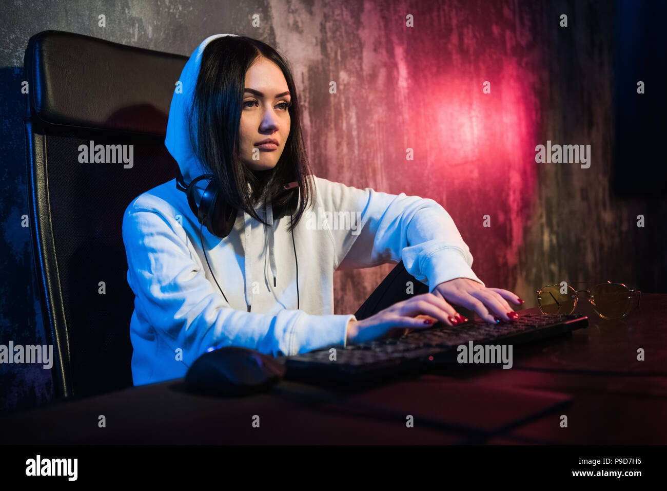 young hooded female hacker developing malware Stock Photo - Alamy