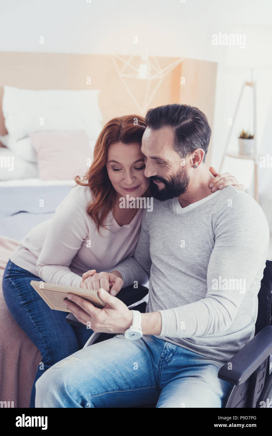 Emotional loving couple smiling while looking at the photo Stock Photo ...