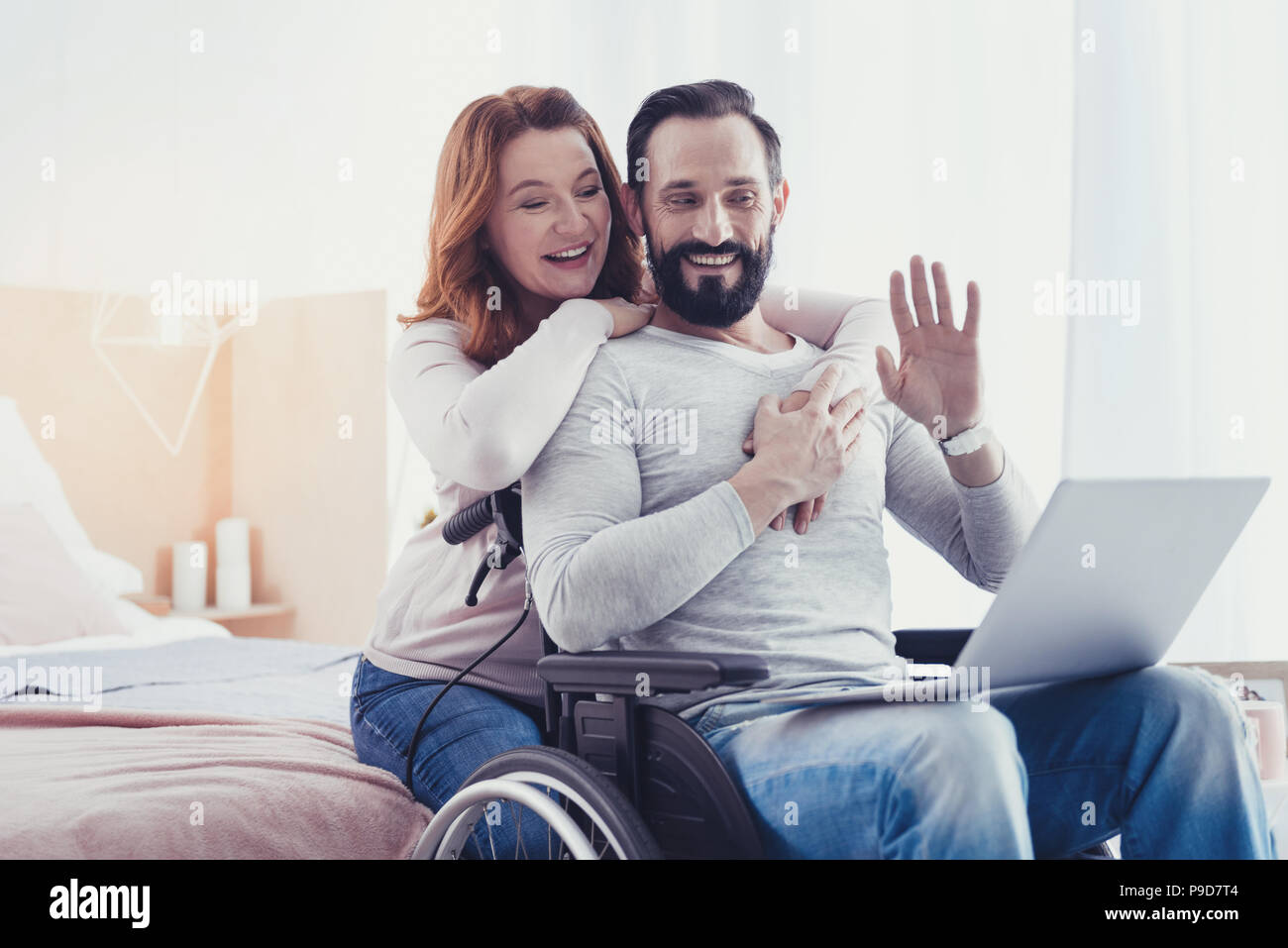 Happy disabled man smiling while having a video call with friends Stock ...