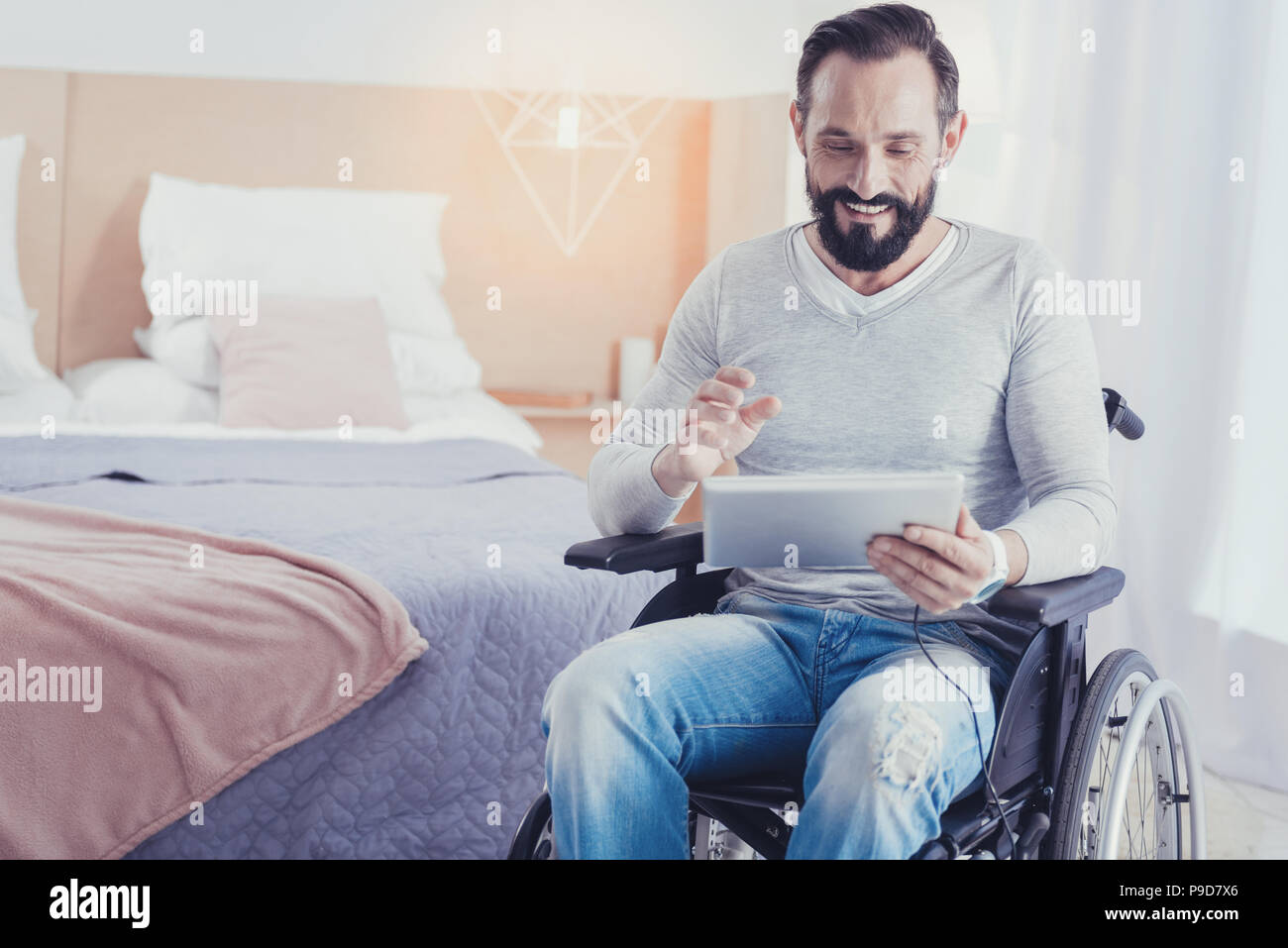Emotional disabled man holding a tablet while having a video call Stock ...