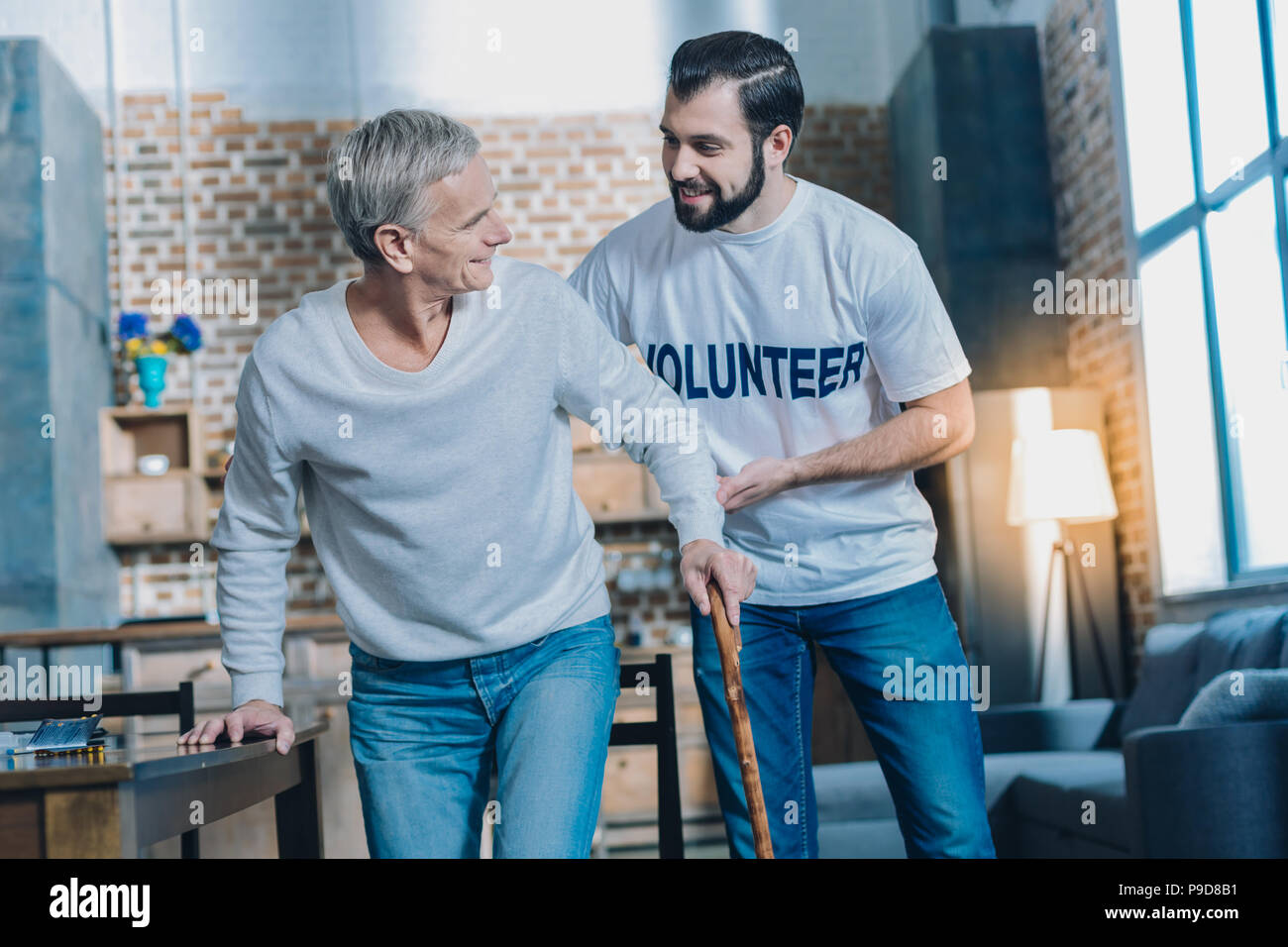 Kind content man helping an aged man Stock Photo - Alamy