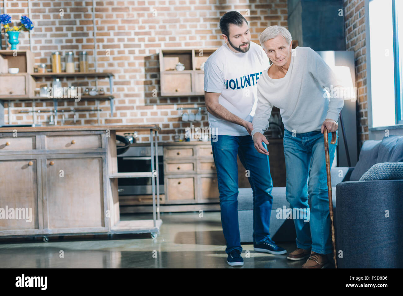 Kind happy man helping an aged man Stock Photo - Alamy