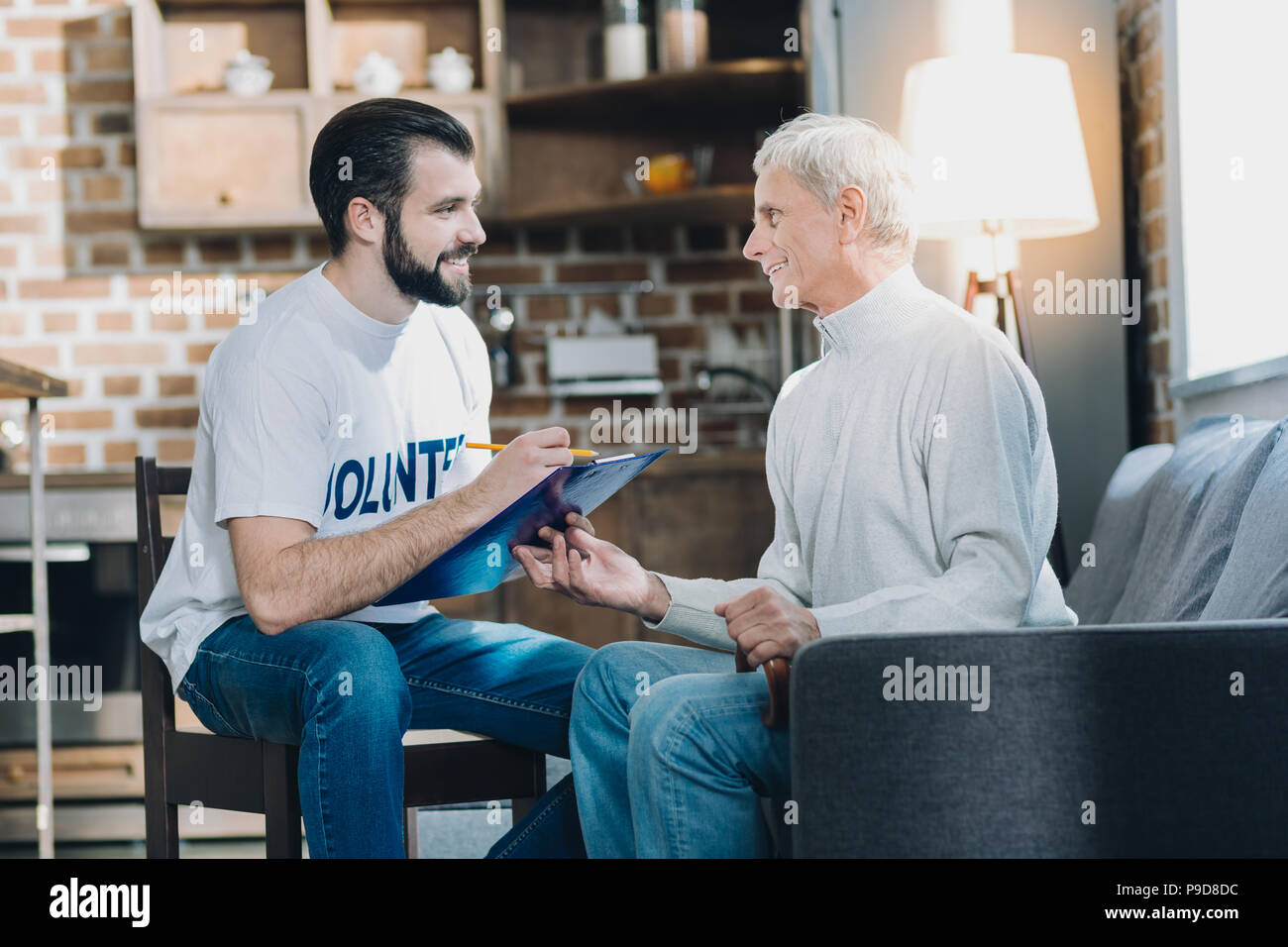 Alert volunteer talking with an old man Stock Photo - Alamy