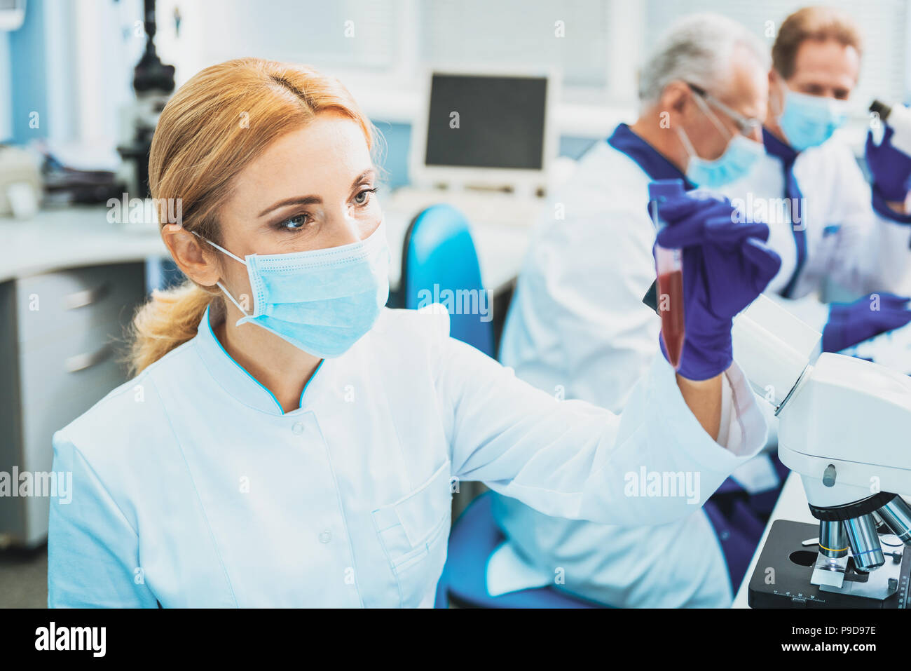 Serious lab assistant checking analysis Stock Photo - Alamy