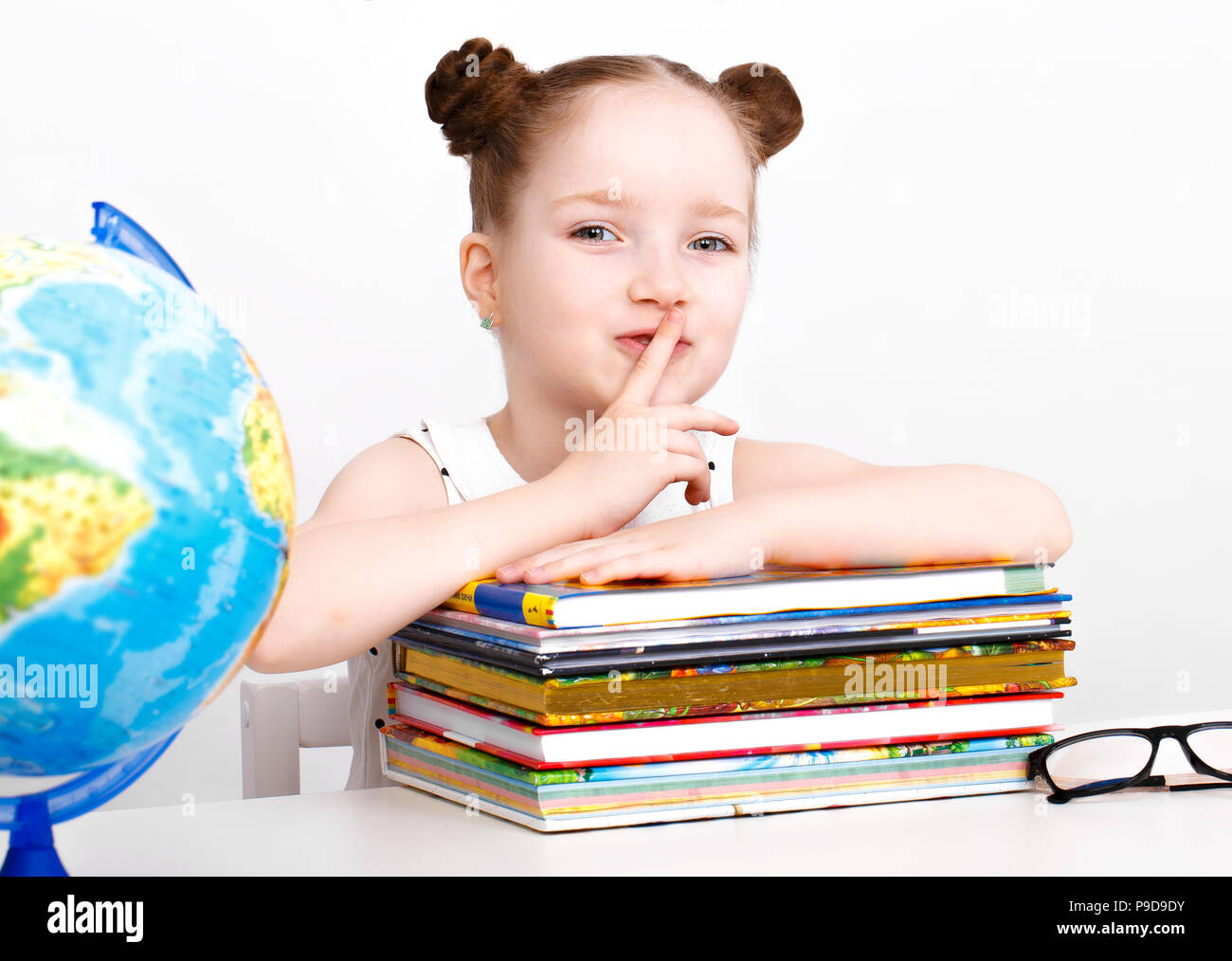 Funny little girl at the table of a first-grader Stock Photo - Alamy