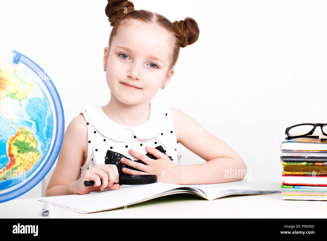 Funny little girl at the table of a first-grader Stock Photo - Alamy