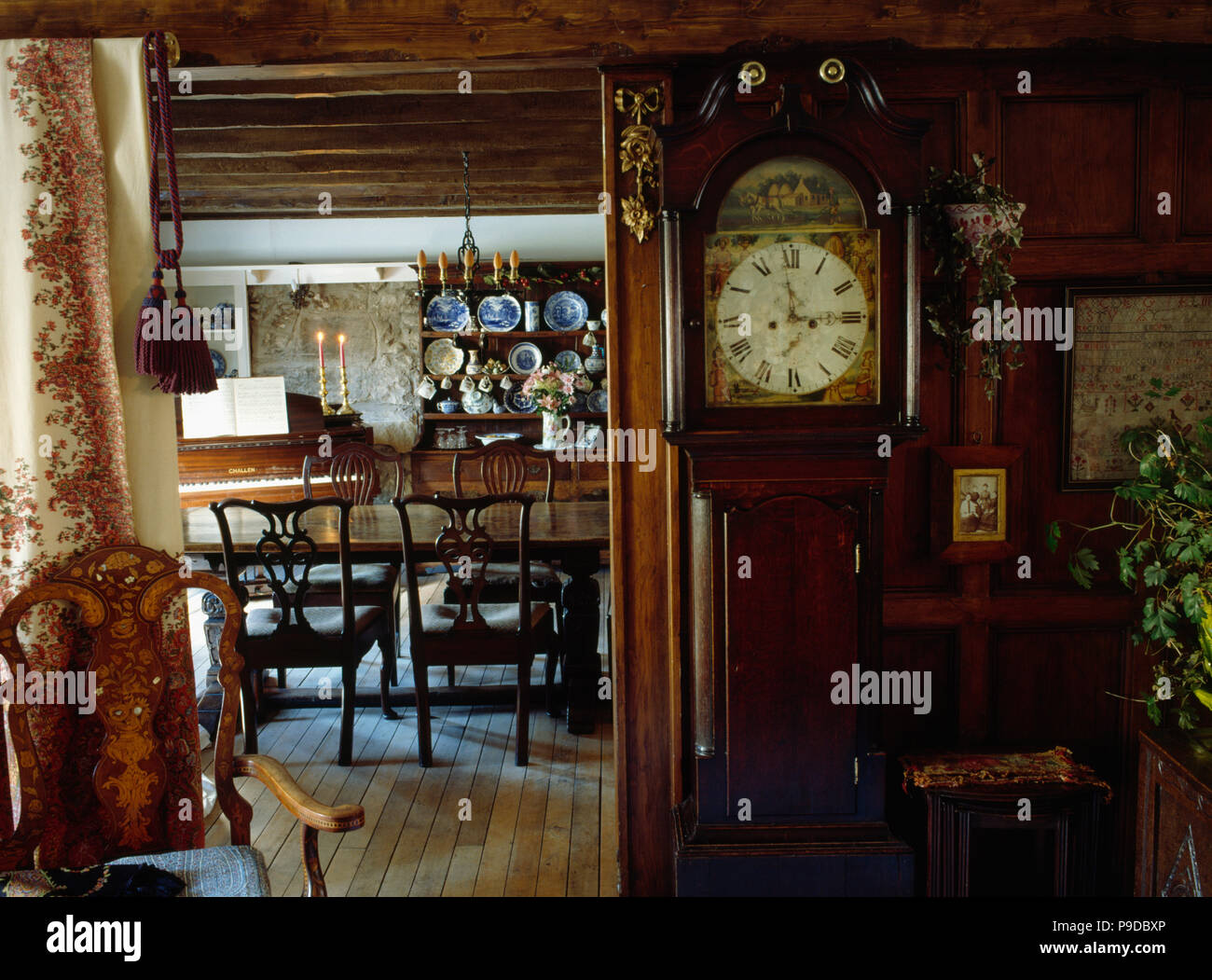 Longcase clock beside open doorway to dining room in country cottage ...