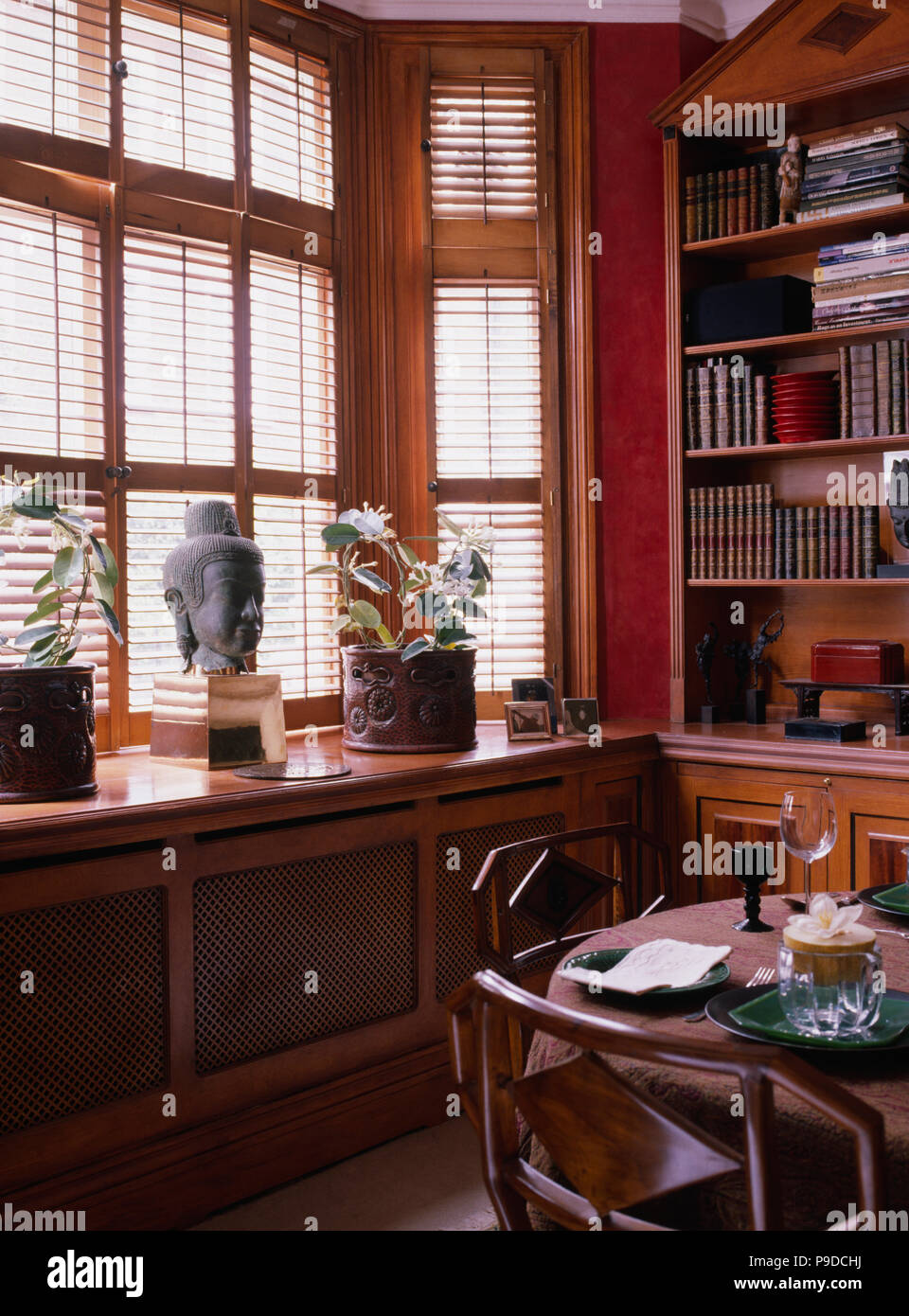 Plantation shutters in red dining room with fretwork radiator cover and ...