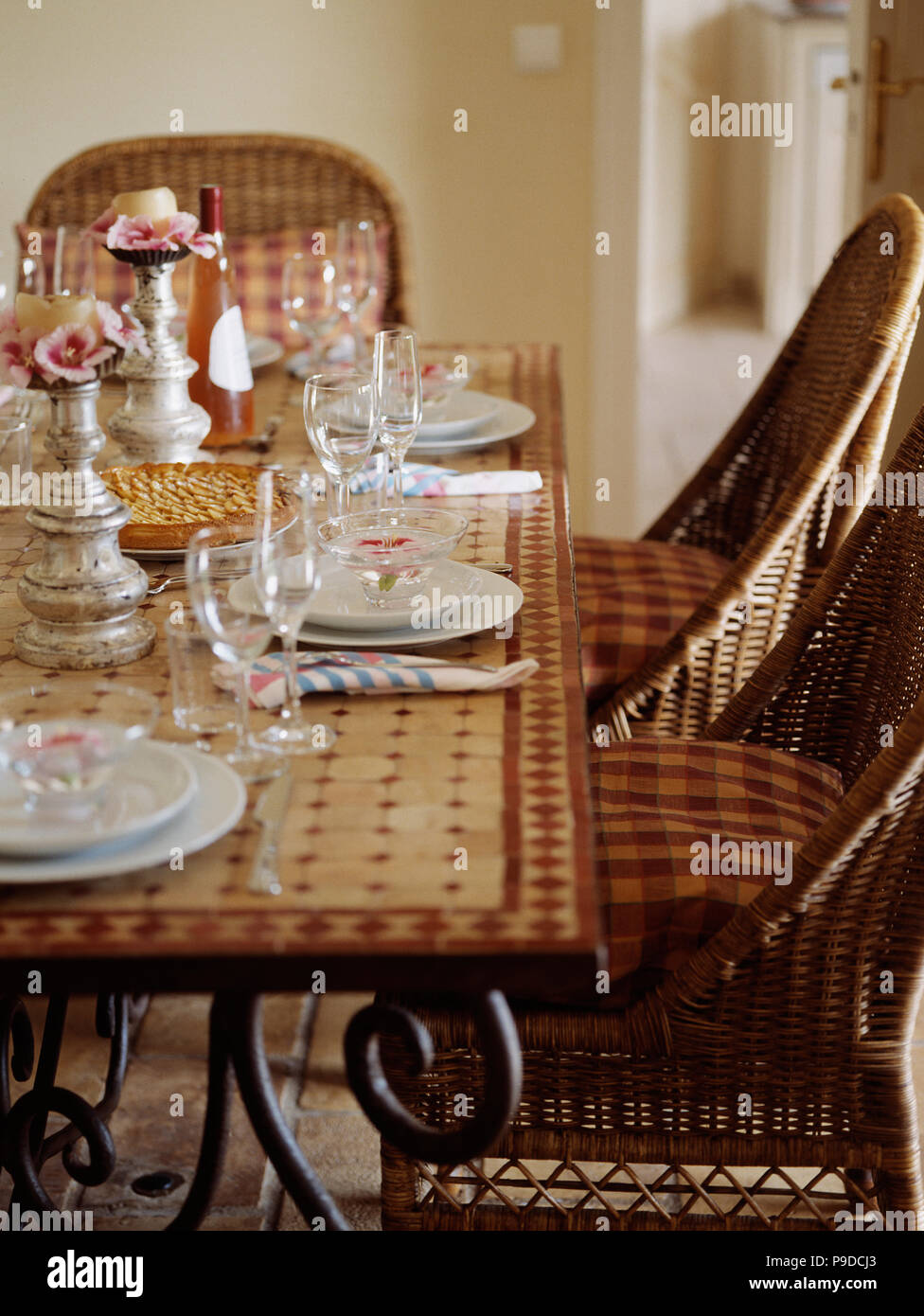 Close-up of tile-topped table set for lunch with wine-glasses and white ...