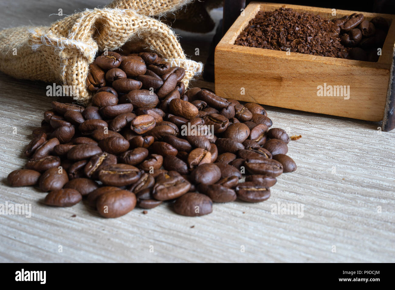 Roasted brown coffee beans with small sack on wooden table background Stock Photo - Alamy