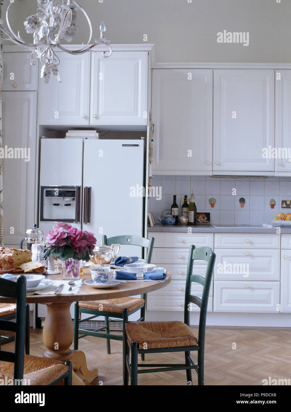 Wooden table and chairs in traditional white kitchen Stock Photo - Alamy