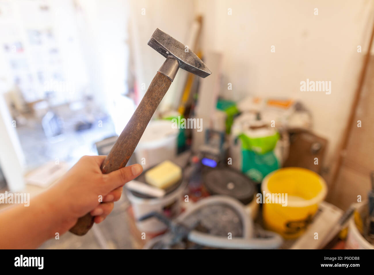 Hand holds a hammer on construction side Stock Photo - Alamy