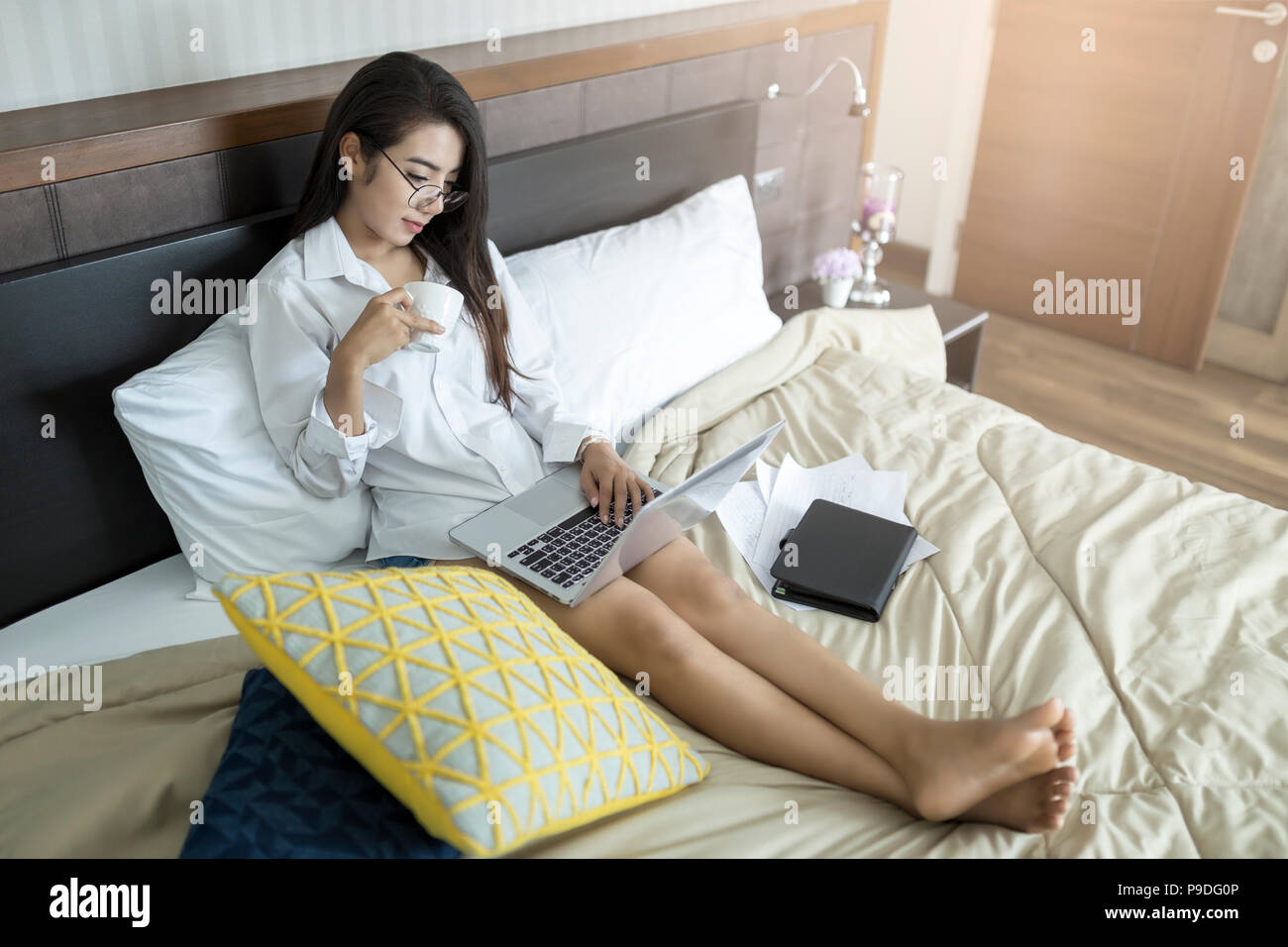 Asia woman working on bed with laptop in bed room Stock Photo - Alamy
