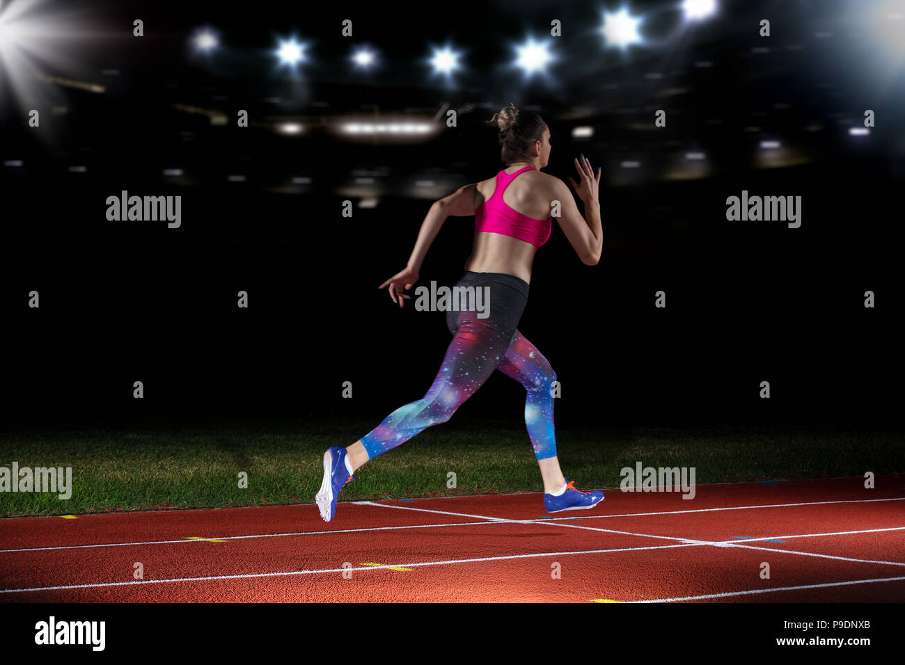 woman sprinter leaving starting blocks on the athletic track. exploding ...