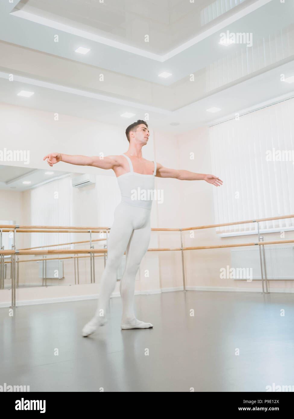 Young handsome male dancer practicing in classical ballet in small ...
