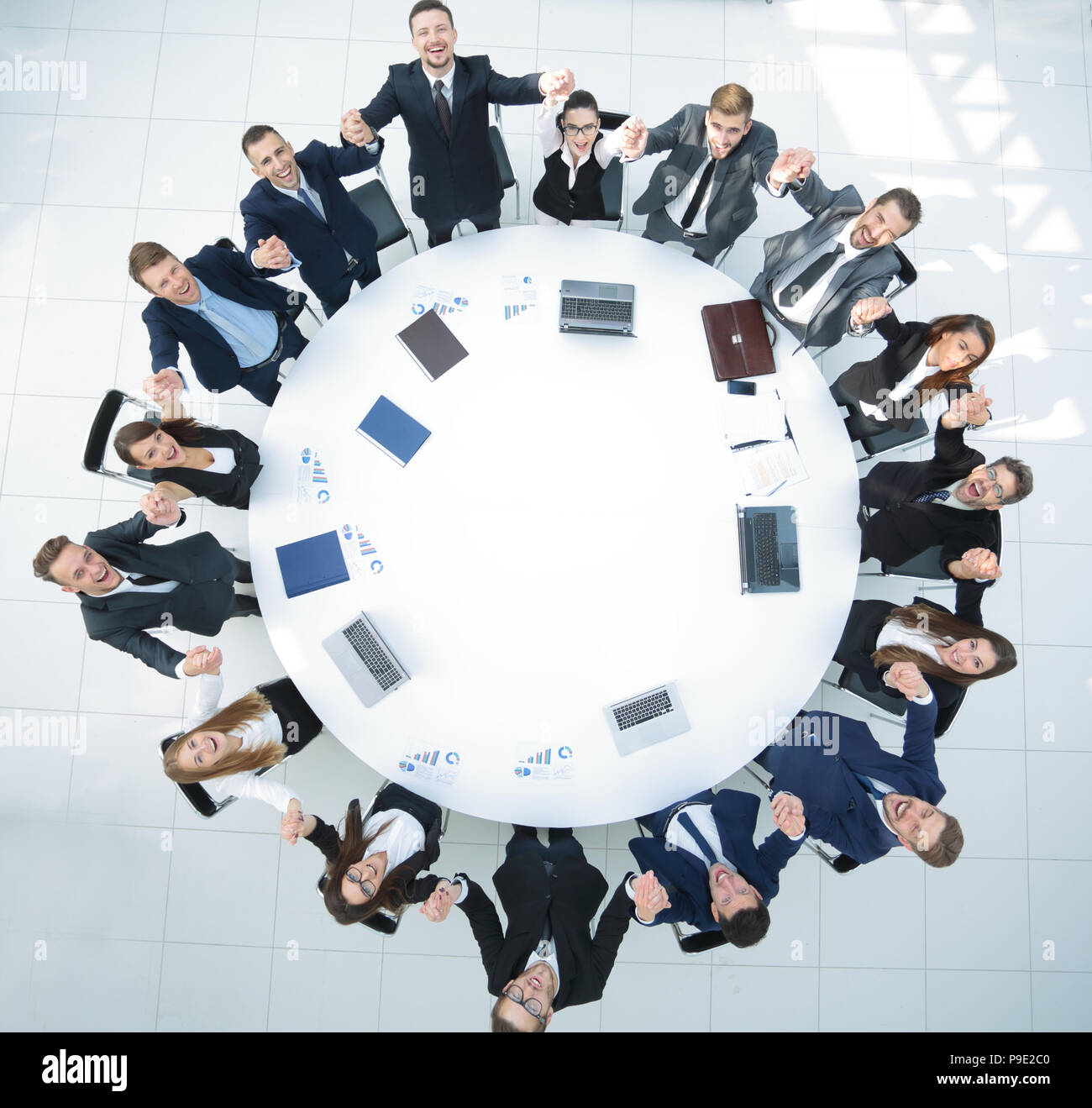large business team sitting at the round table and raising his hands up ...