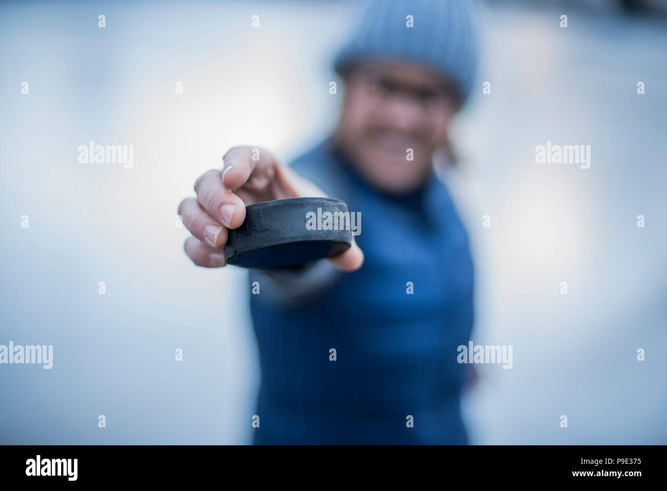 Girl holds hockey puck at arms length, shallow depth of field Stock ...