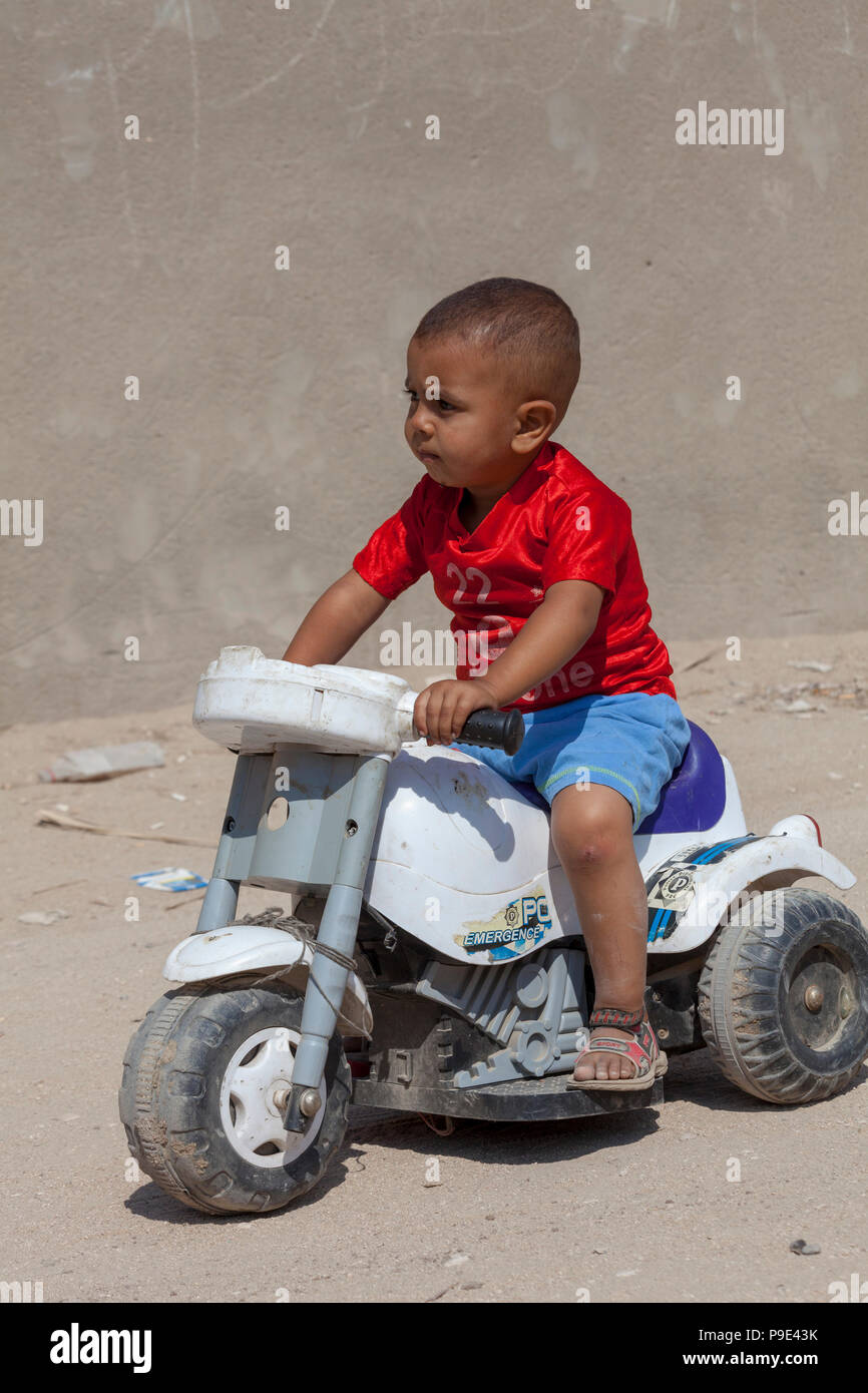 small boy riding tricycle on unpaved street in Cairo, Egypt Stock Photo ...