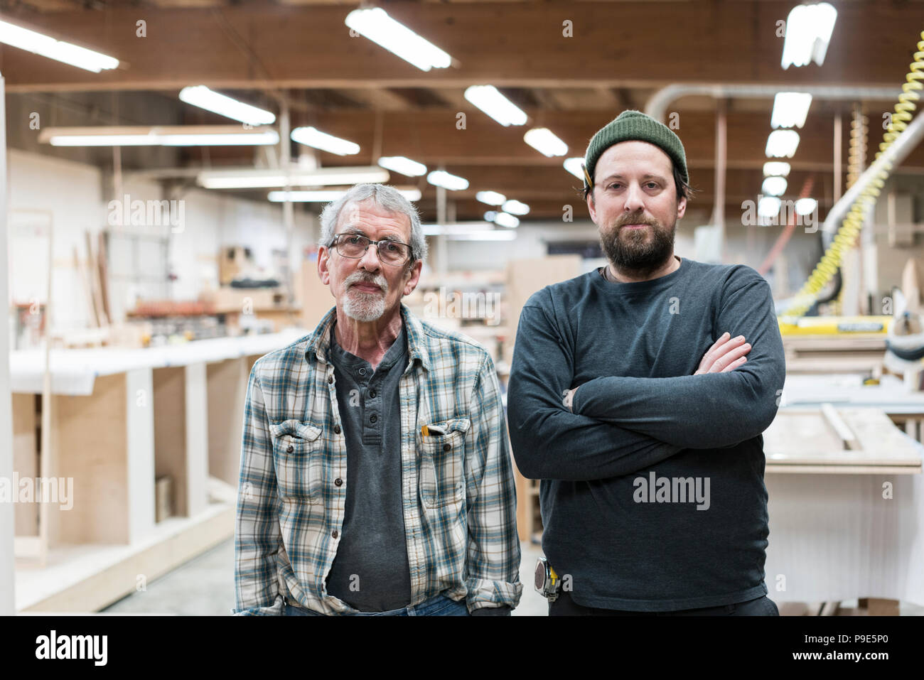 Portrait of two Caucasian carpenters in a large woodworking factory ...