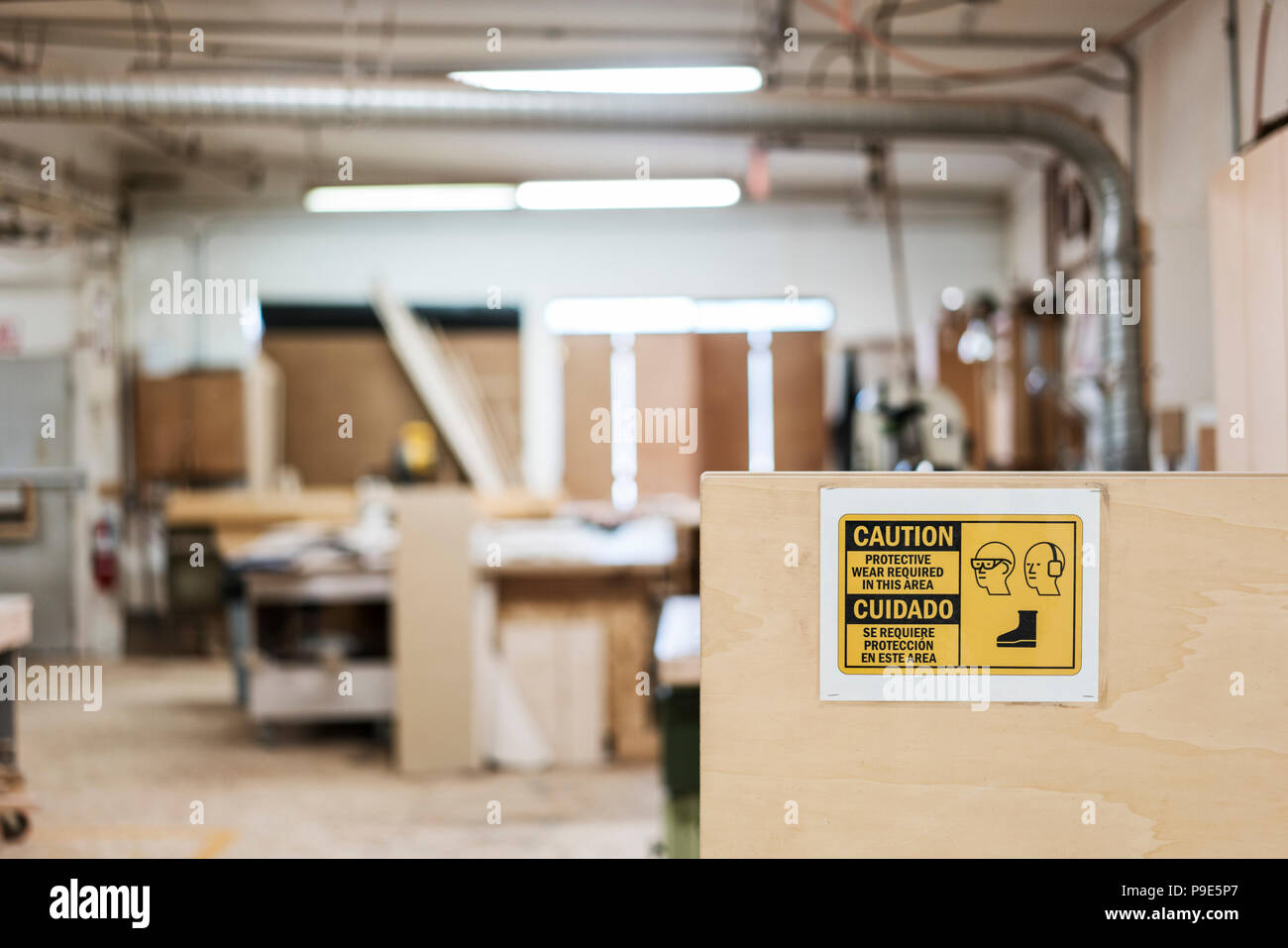 Interior of a woodworking factory showing a sign for safety gear ...