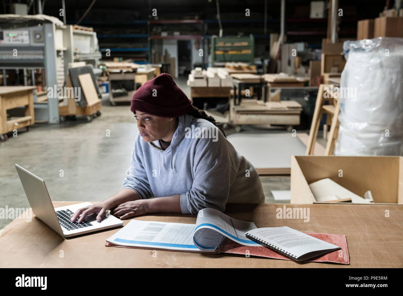 A Black female carpenter working on a lap top computer after work hours ...
